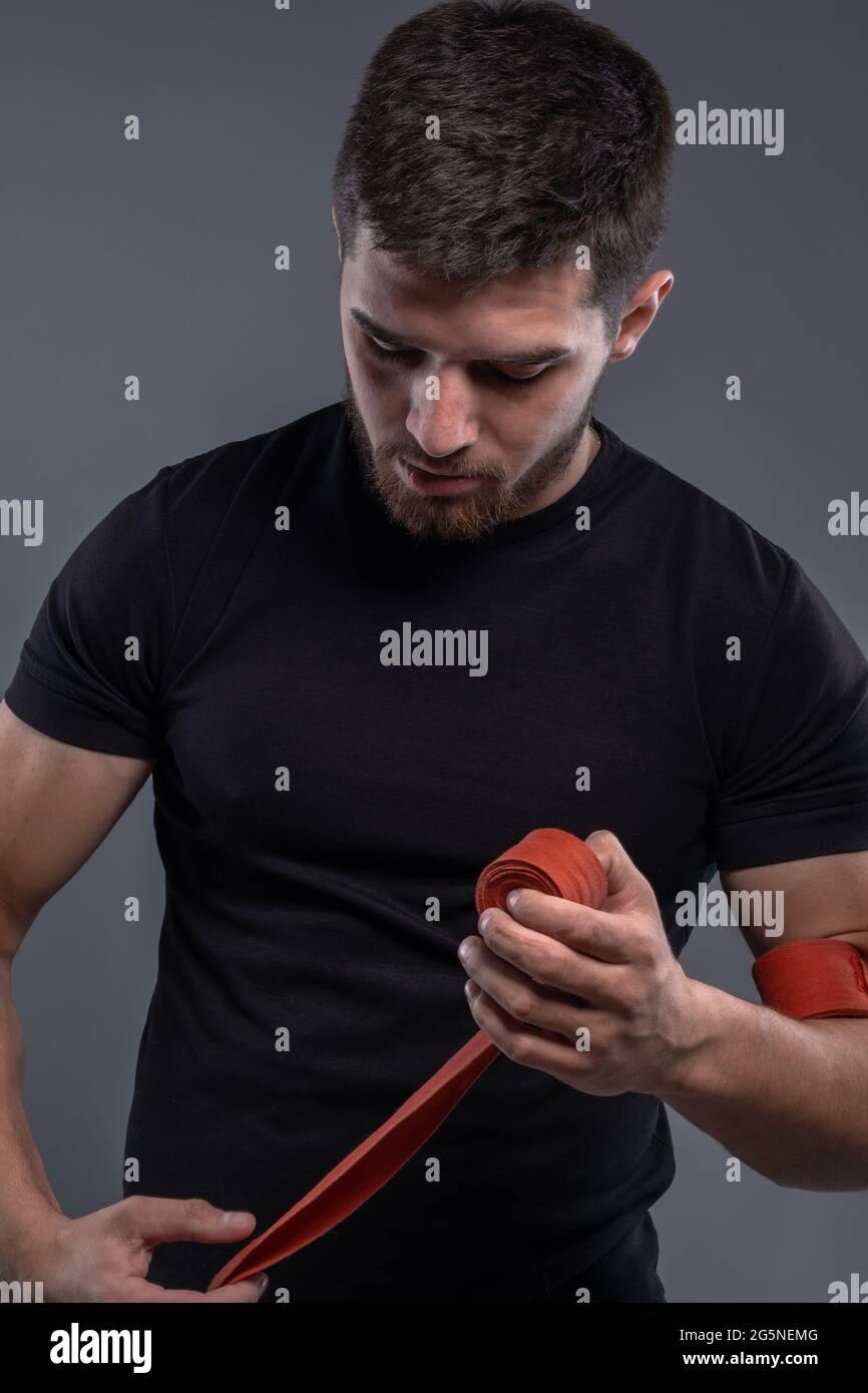 Young man twisting elastic tape after boxing workout Stock Photo - Alamy