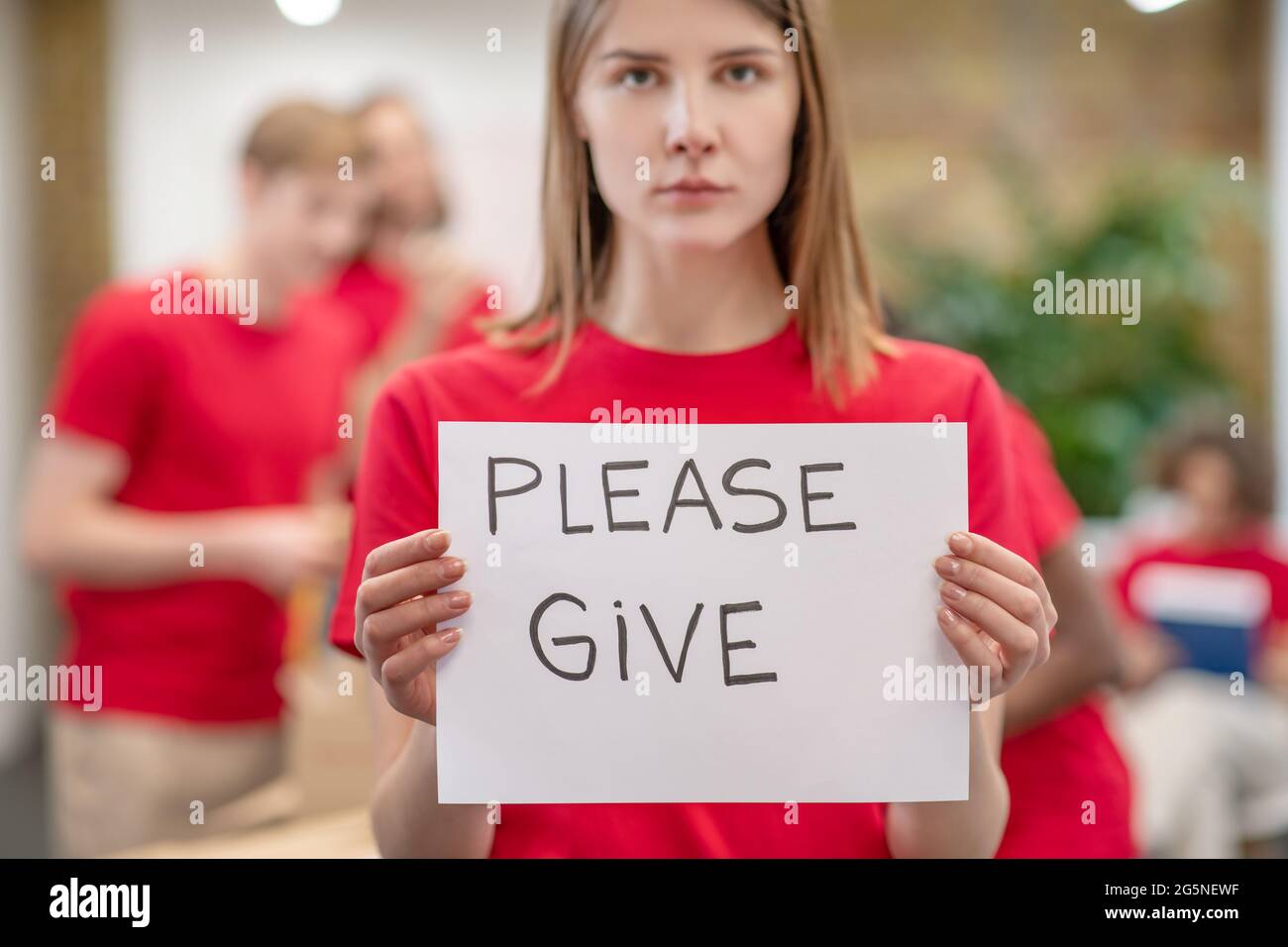 Girl volunteer with poster in her hands Stock Photo - Alamy