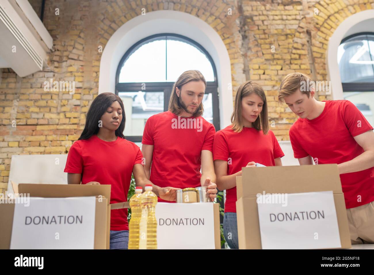 Student volunteers packing donation boxes together Stock Photo - Alamy