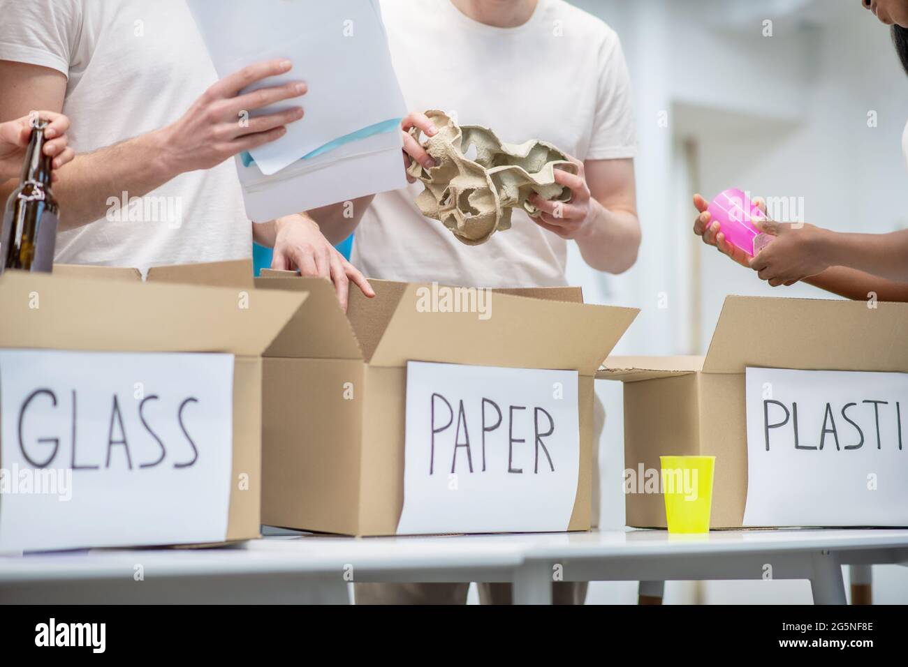 Young people sorting trash into appropriate boxes Stock Photo - Alamy