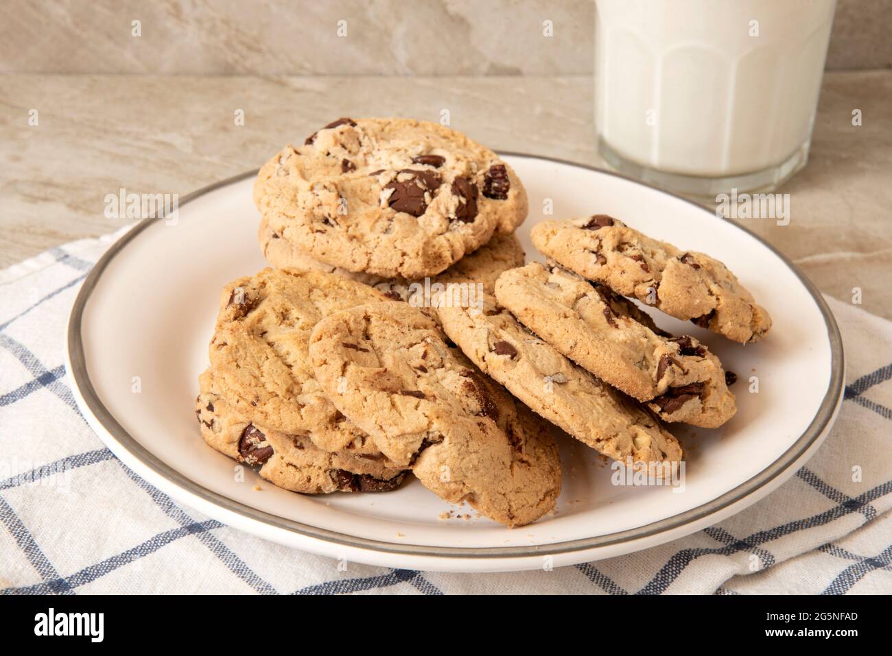 A plate of chocolate chip cookies with a glass of milk on a kitchen ...