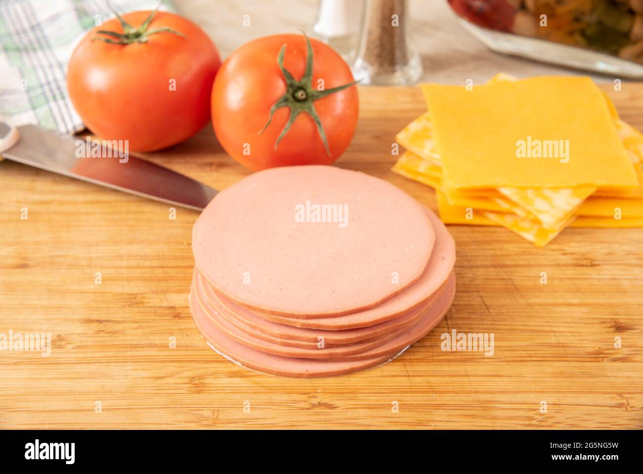 Stacks of beef bologna, colby and cheddar cheese on a cutting board ...