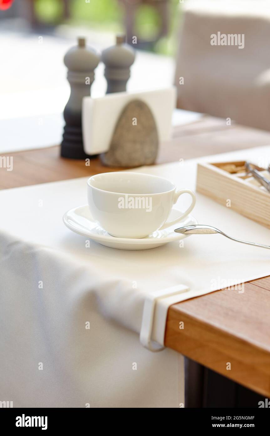 Hot coffee in a cup on wooden table. Modern design interior, restaurant blur background with ...