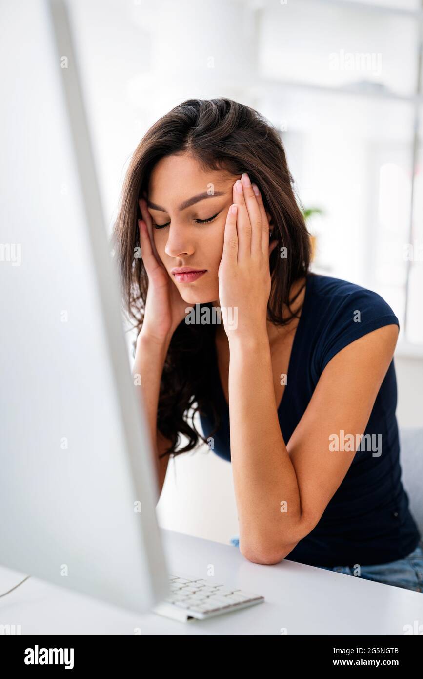 Portrait of tired young business woman with laptop computer Stock Photo ...