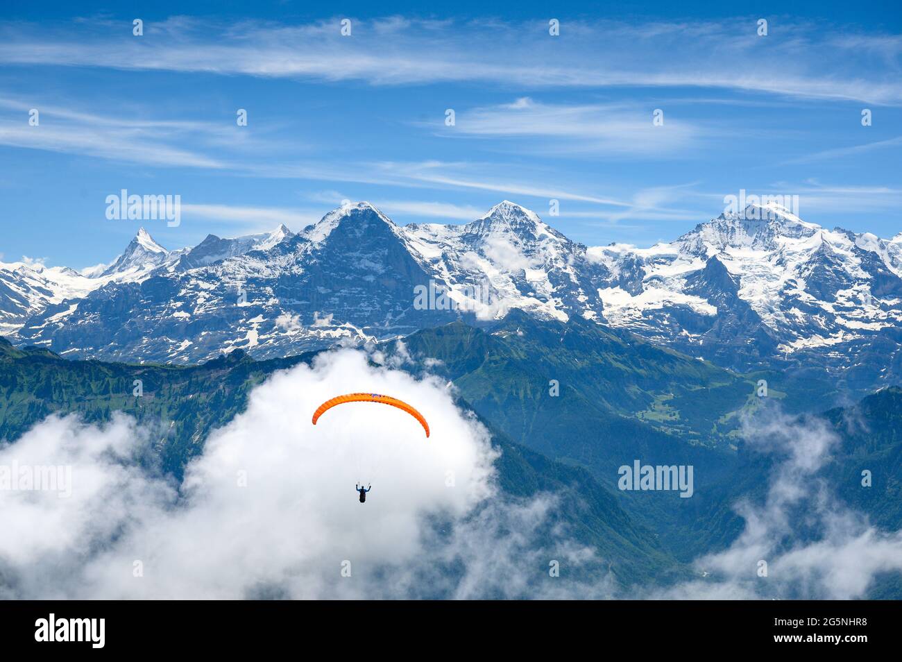 paragliding flyer in the Bernese Alps in front of Eiger Mönch and ...