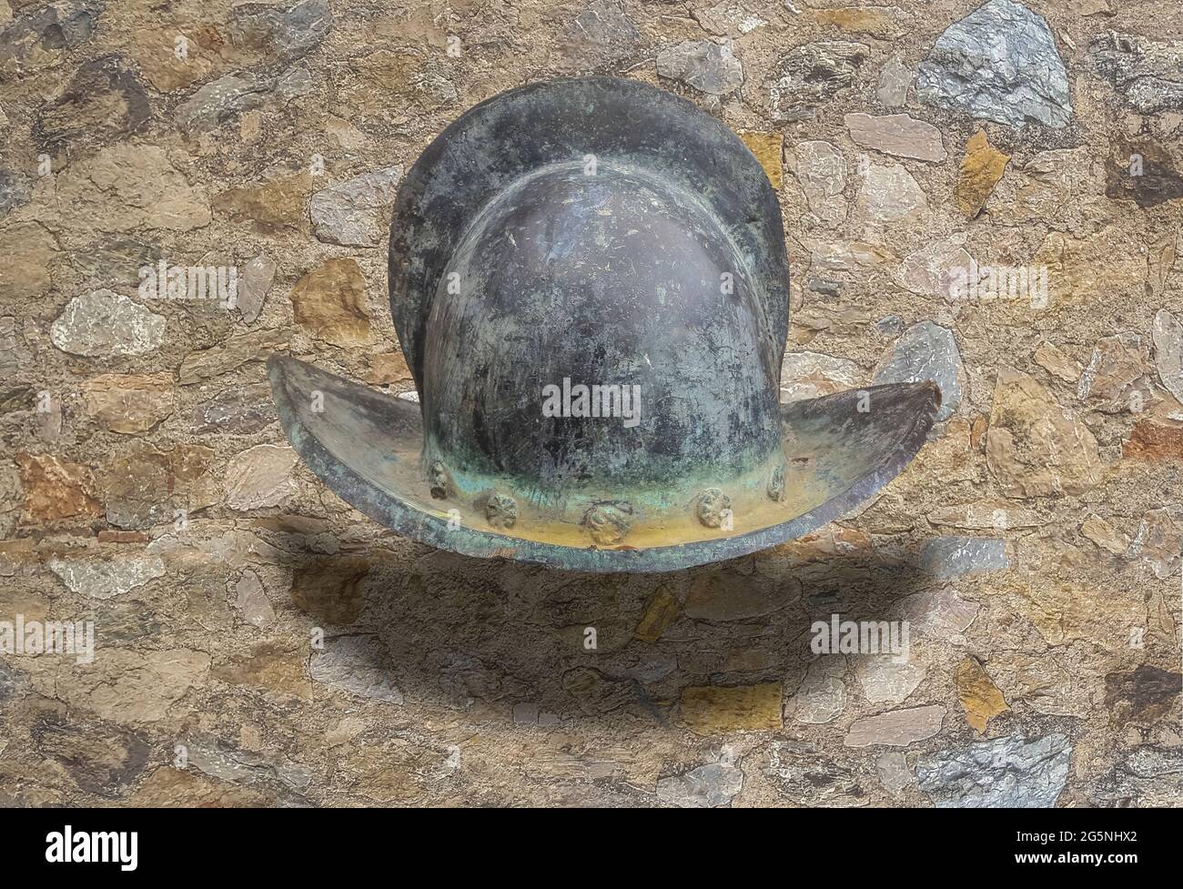 16h Century crested helmet morion. Isolated over stone wall background ...