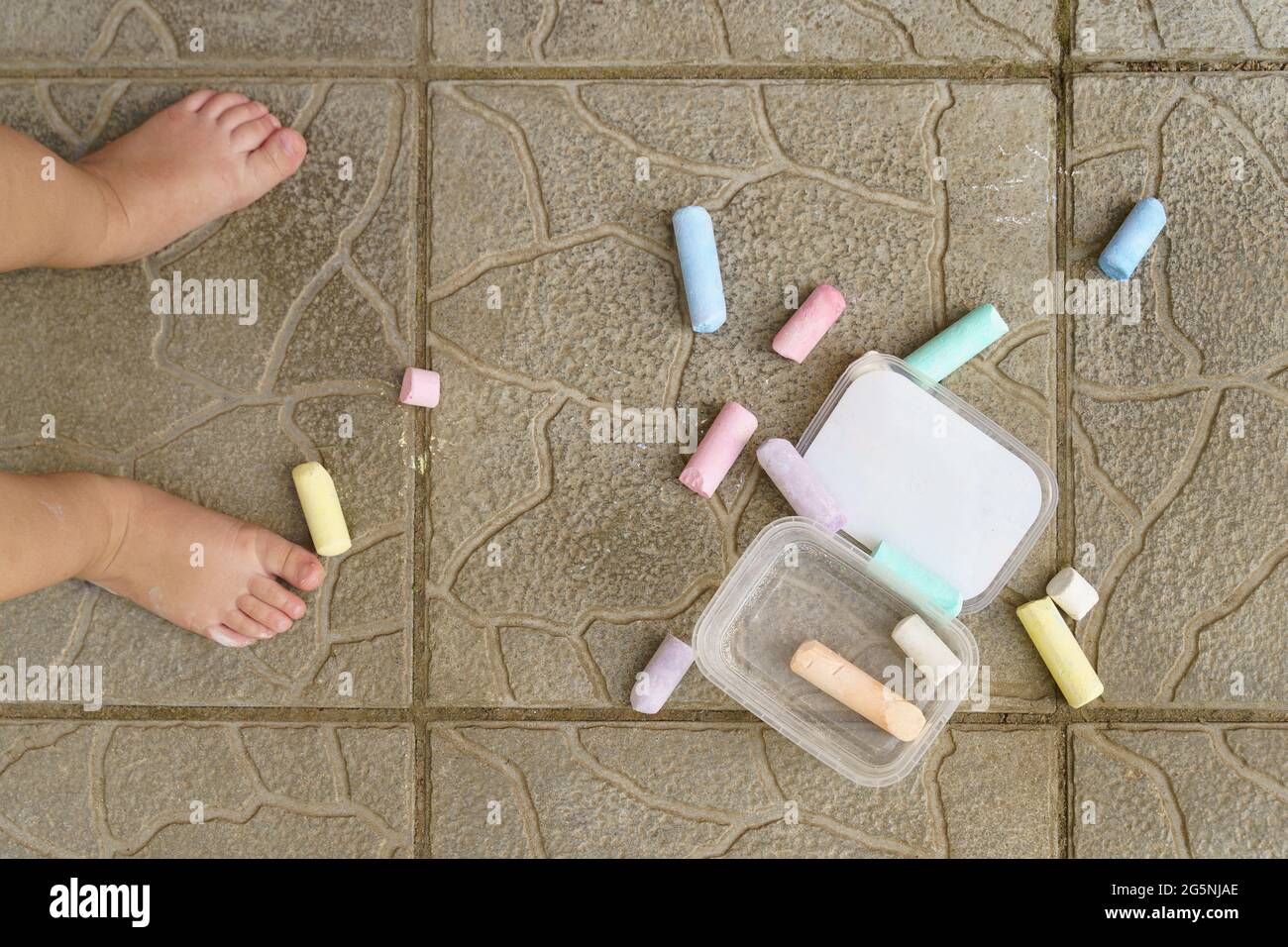 Flat lay pieces of colors chalk on the floor and toddler kid legs Stock ...