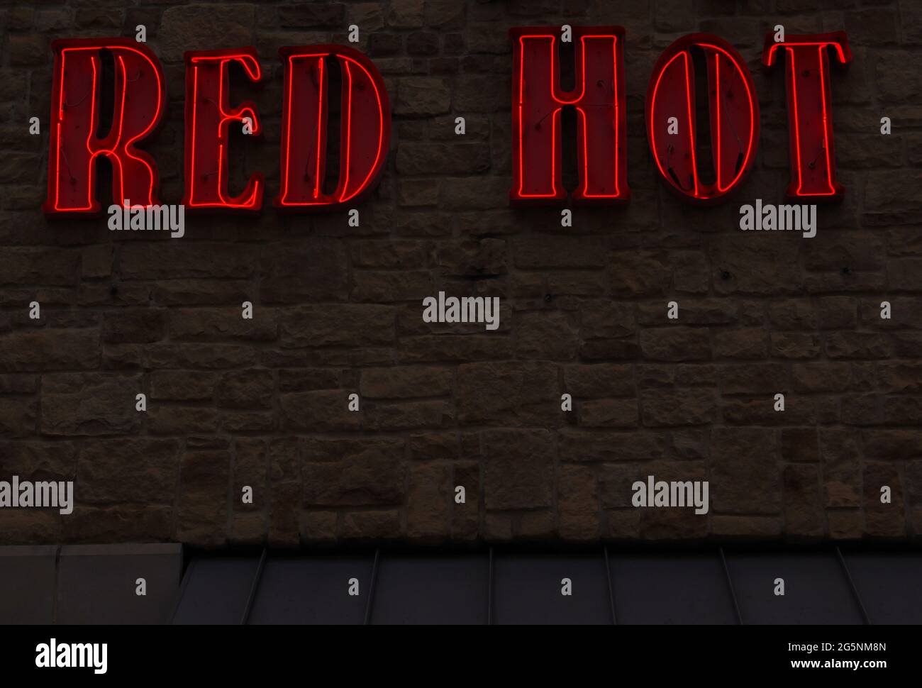 Neon Red Hot Sign on Brick Wall Stock Photo - Alamy