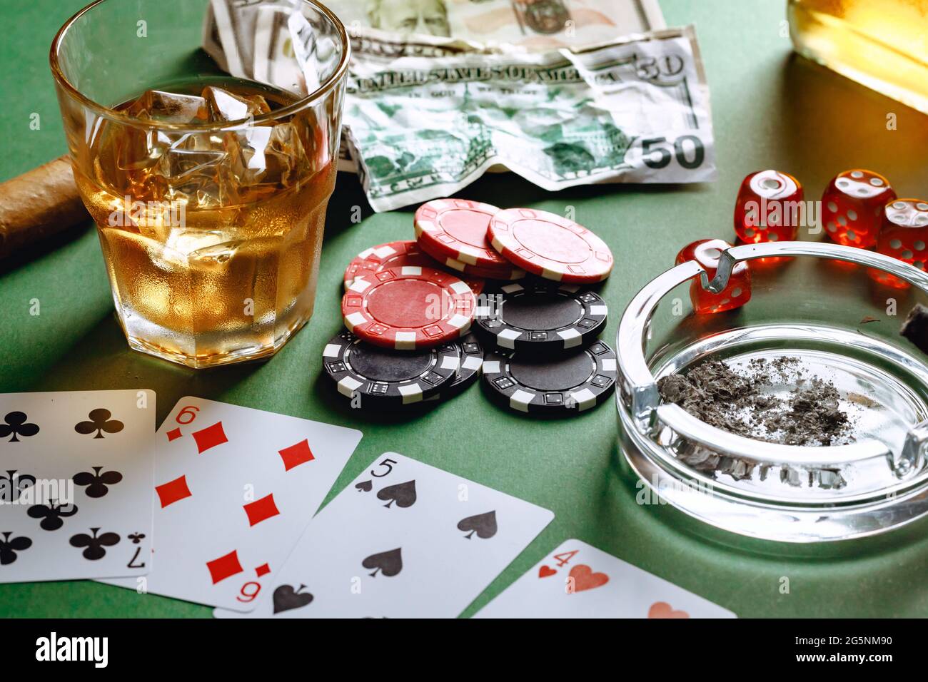 Glass of whiskey, cigar, playing cards and chips on green background ...
