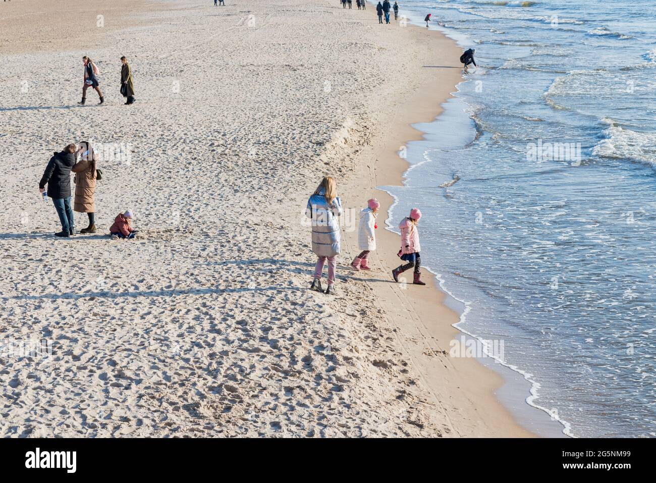 Several of people walking on the beach in spring.People walking on the ...
