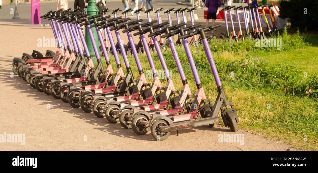 There are a lot of electric scooters in the parking lot in the park ...