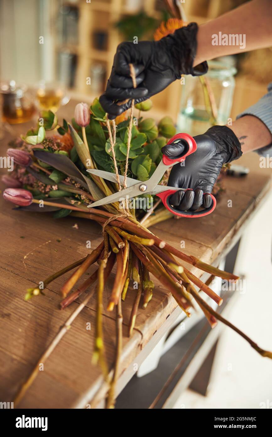 Female hands cutting a string wrapped around a flower bunch Stock Photo ...