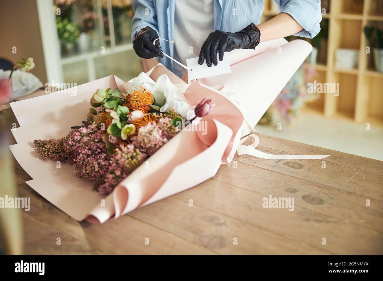 Female florist finishing off a flower arrangement Stock Photo - Alamy
