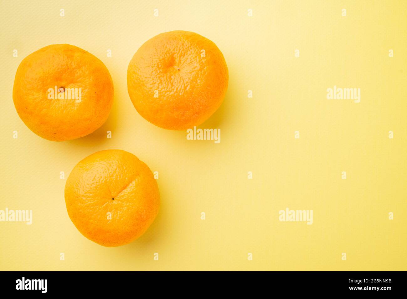 Whole fresh tangerines set, on yellow textured summer background, top ...