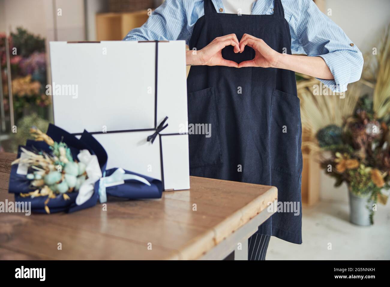 Floral boutique worker showing a heart shape hand gesture Stock Photo ...