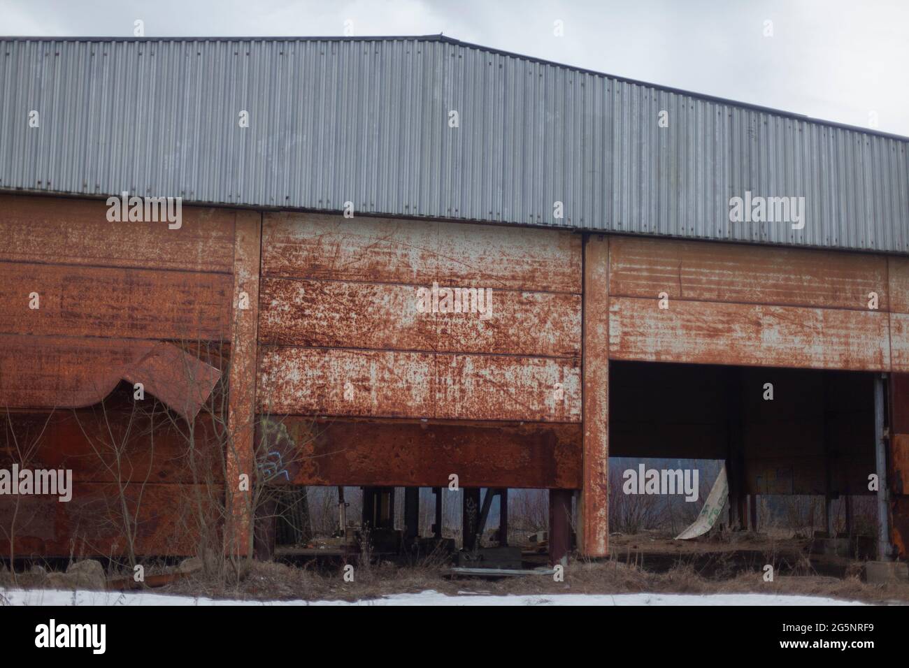 Abandoned warehouse-type buildings. A rusty wall at a big house. The ...