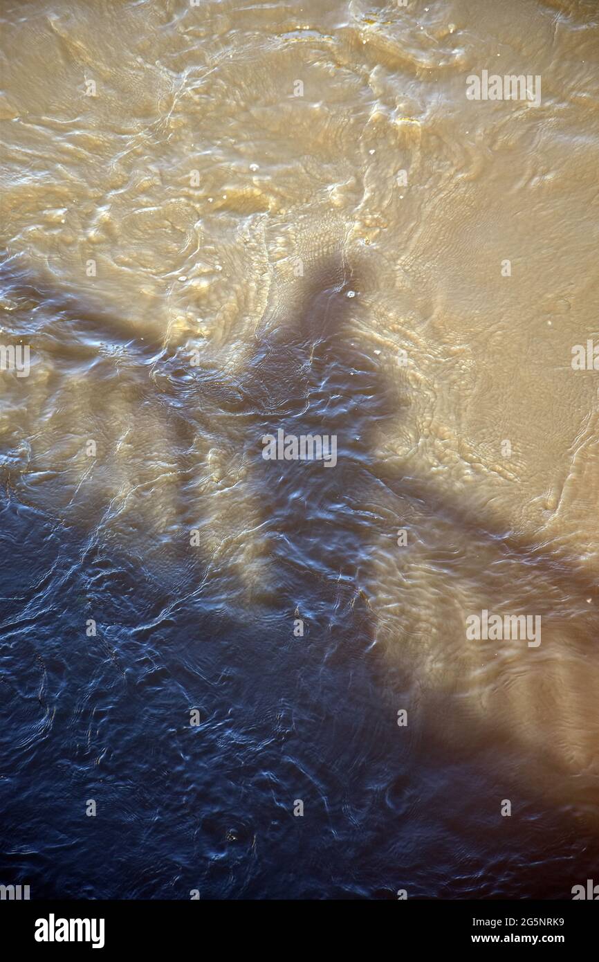 Shadow on the water, shadow of a person, leaning over the rail of the ...