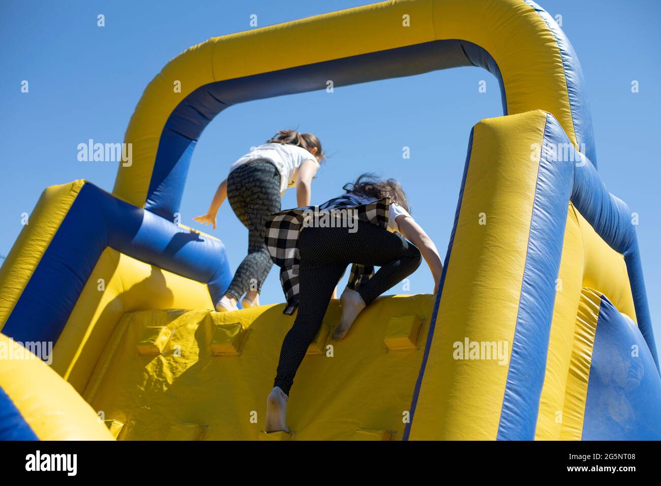 Children climb an inflatable slide. Inflatable obstacle course for fun ...