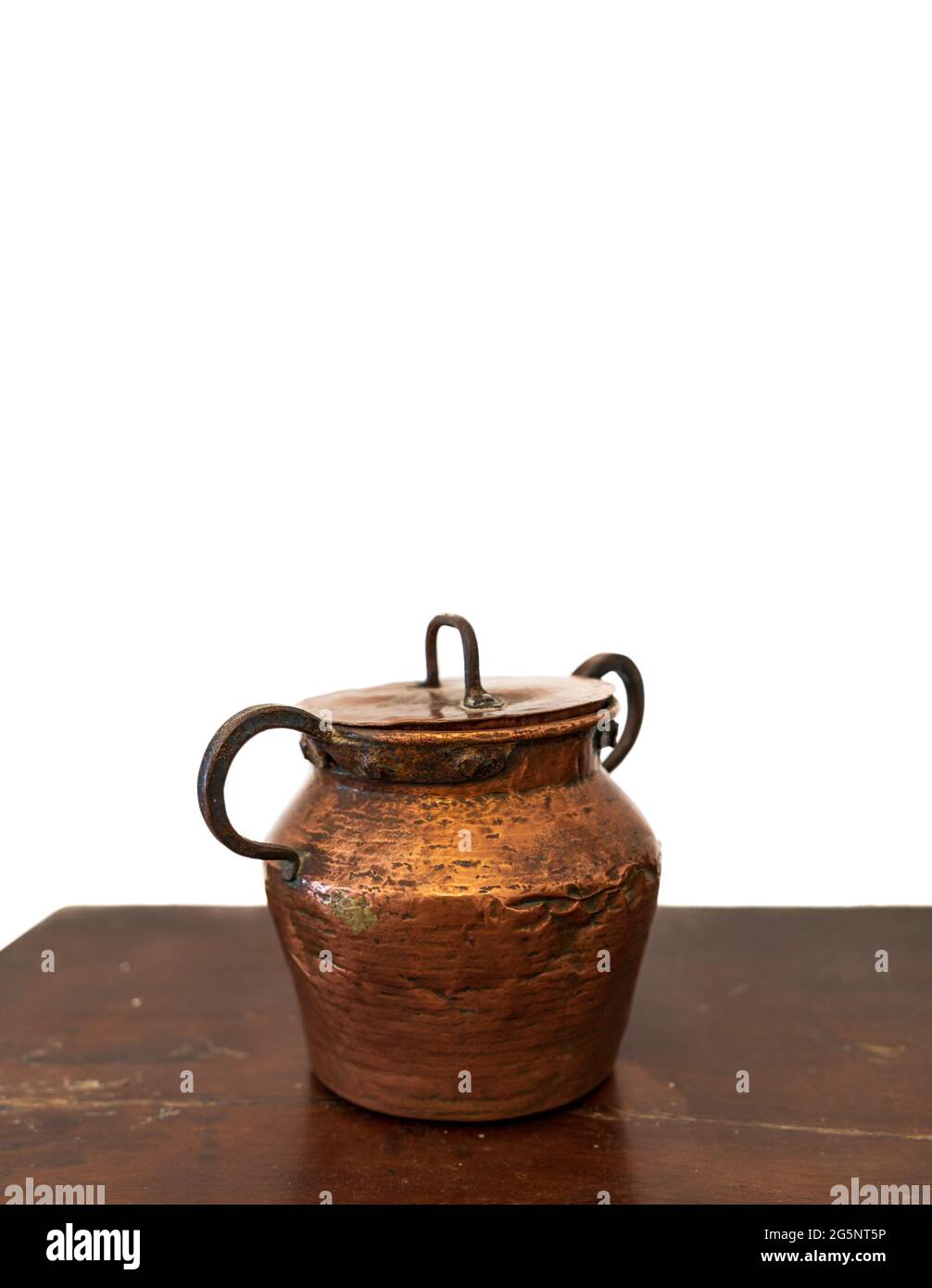 Antique copper pot with lid over the table and white background Stock ...