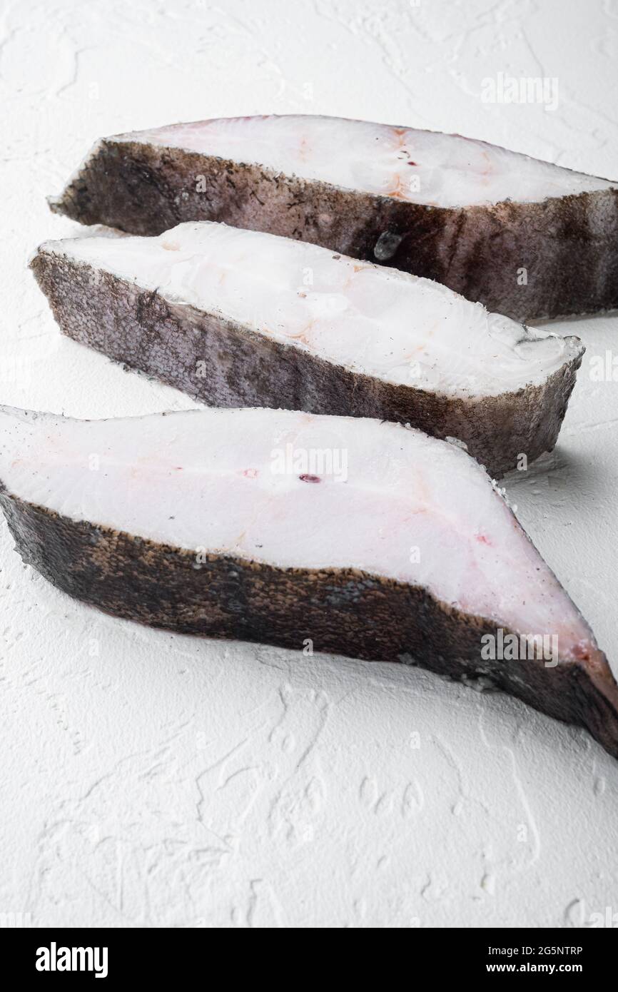 Frozen fillets of white fish, pollock set, on white stone table ...