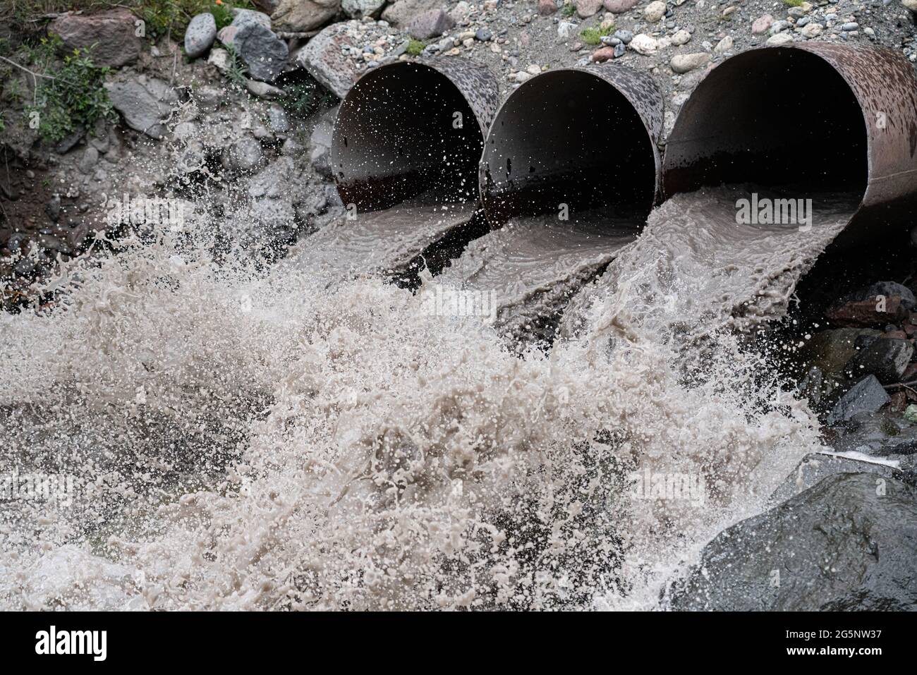 Mountain river flows through pipes Stock Photo - Alamy
