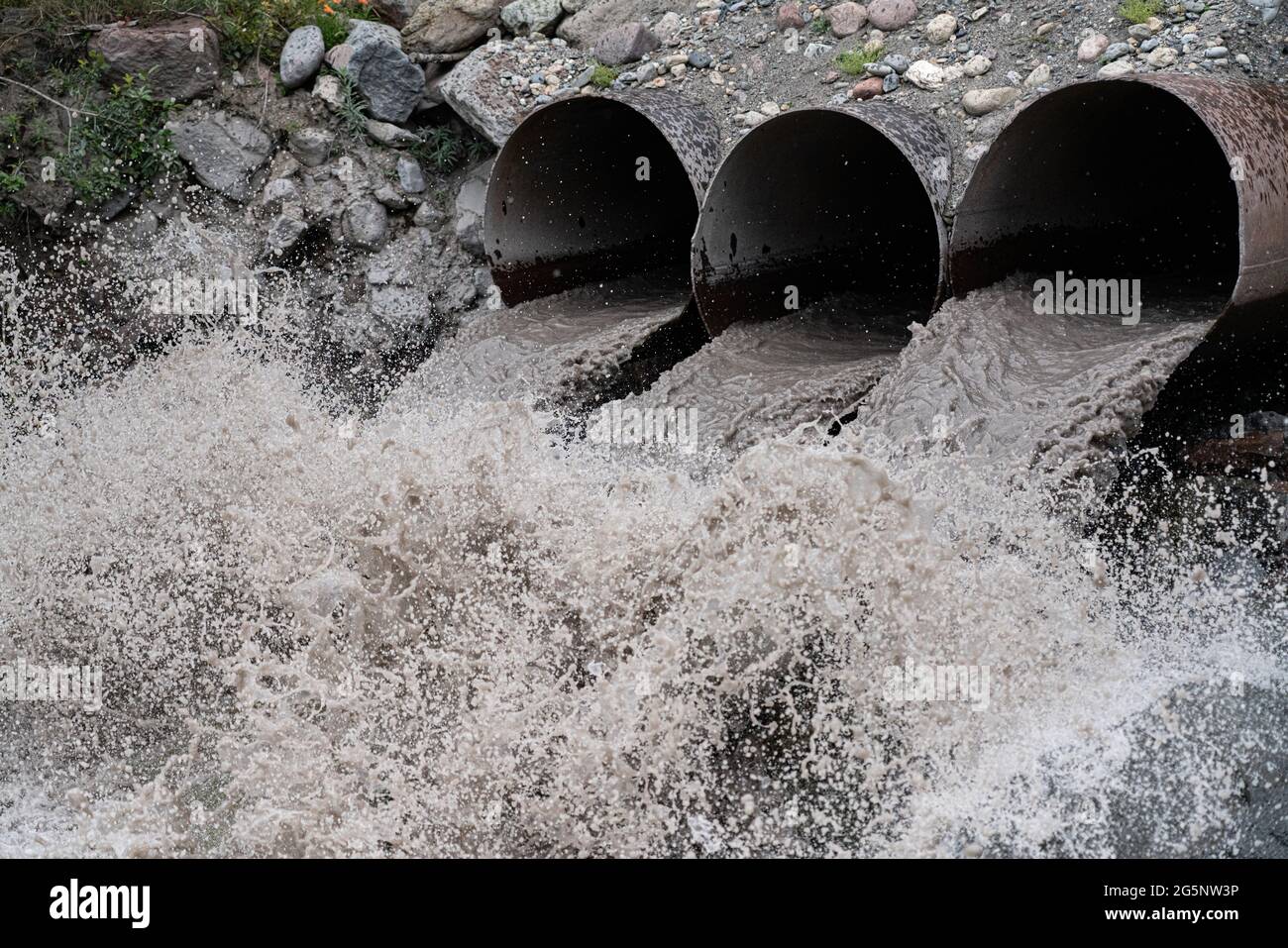 Mountain river flows through pipes Stock Photo - Alamy