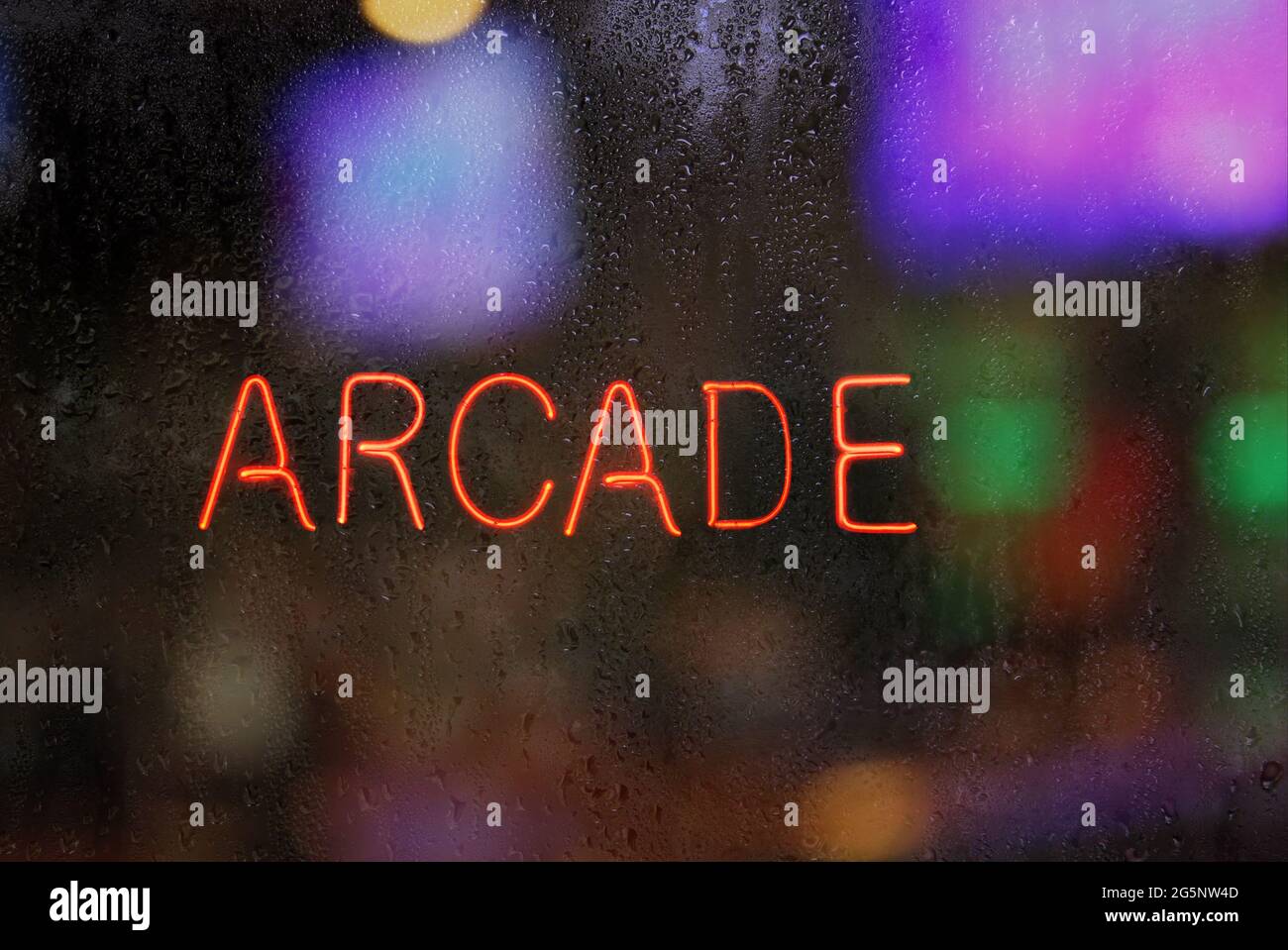 Vintage Neon Arcade Sign in Wet Window Stock Photo - Alamy