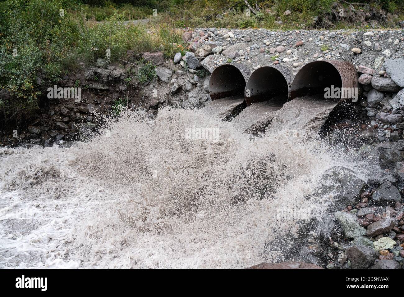 Mountain river flows through pipes Stock Photo - Alamy