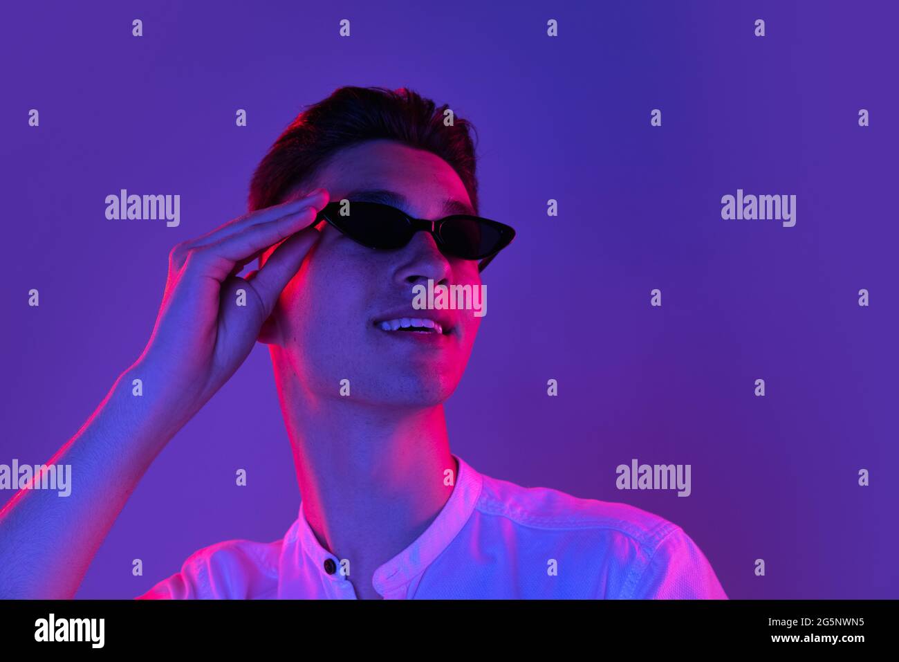 Caucasian young man in sun glasses isolated on blue studio background ...