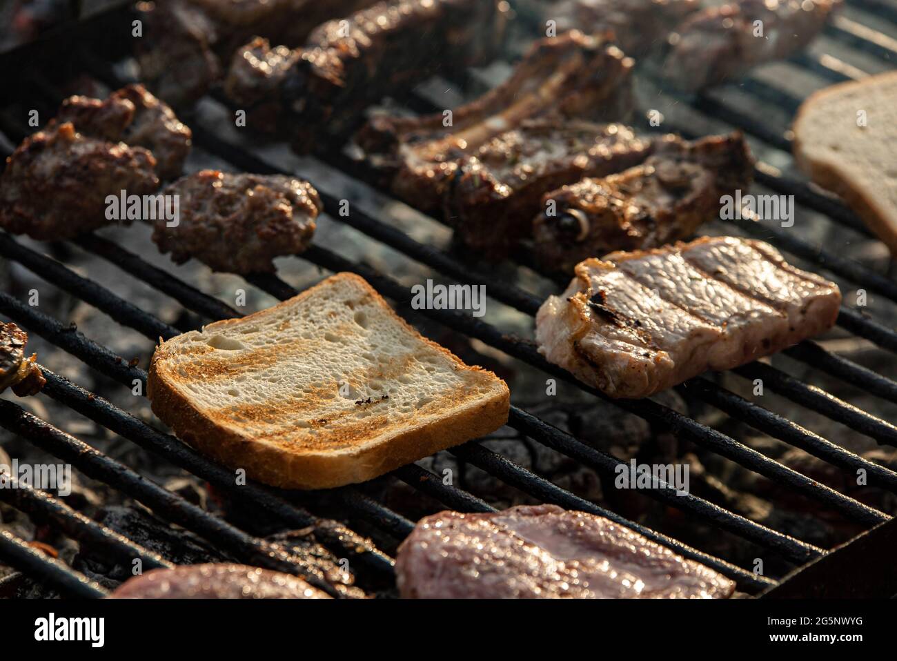 Grilled meat and bread detail, cooking at the grill Stock Photo - Alamy
