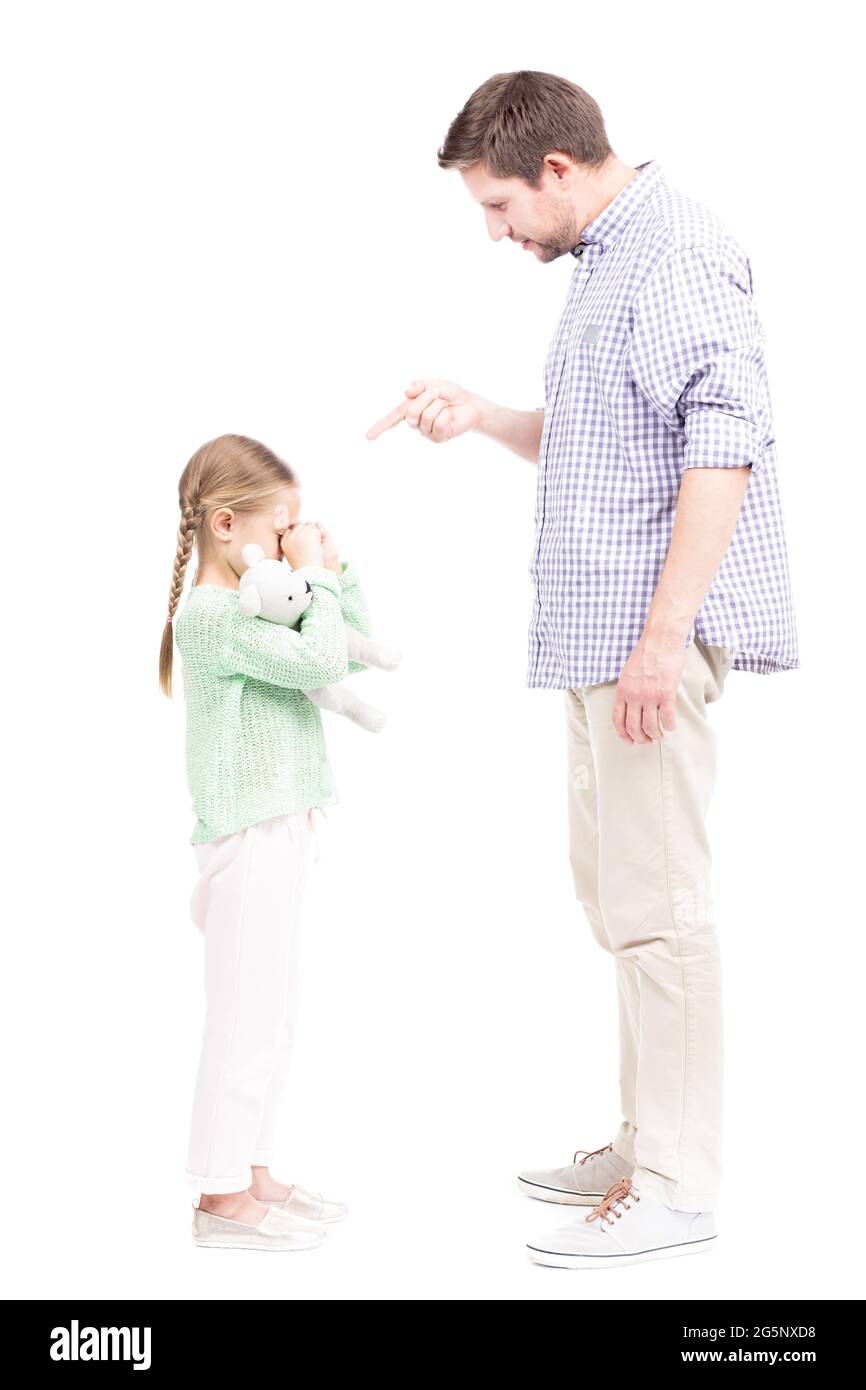 Vertical full length isolated shot of strict father scolding his little ...