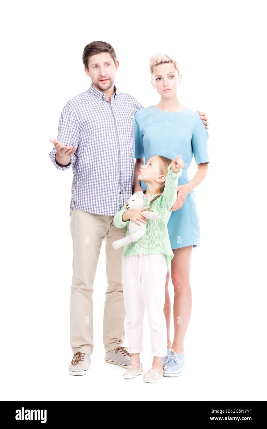 Vertical full length shot of little Caucasian girl showing something to ...