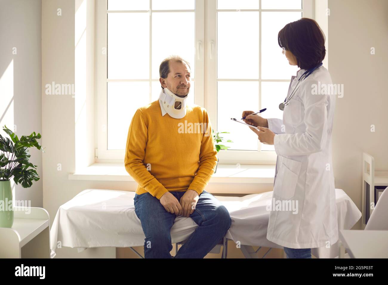 Senior patient wearing a cervical collar listening to his doctor at the ...