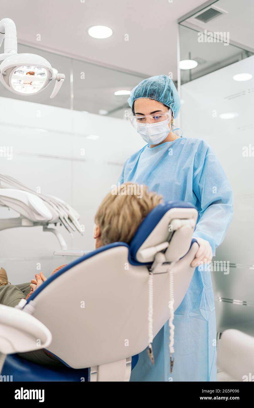Dentist wearing protective face mask and disposable hair net working ...