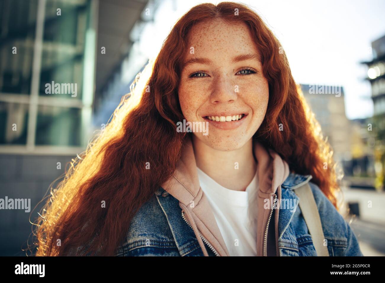 Beautiful student smiling at camera. Close-up of a young woman standing ...