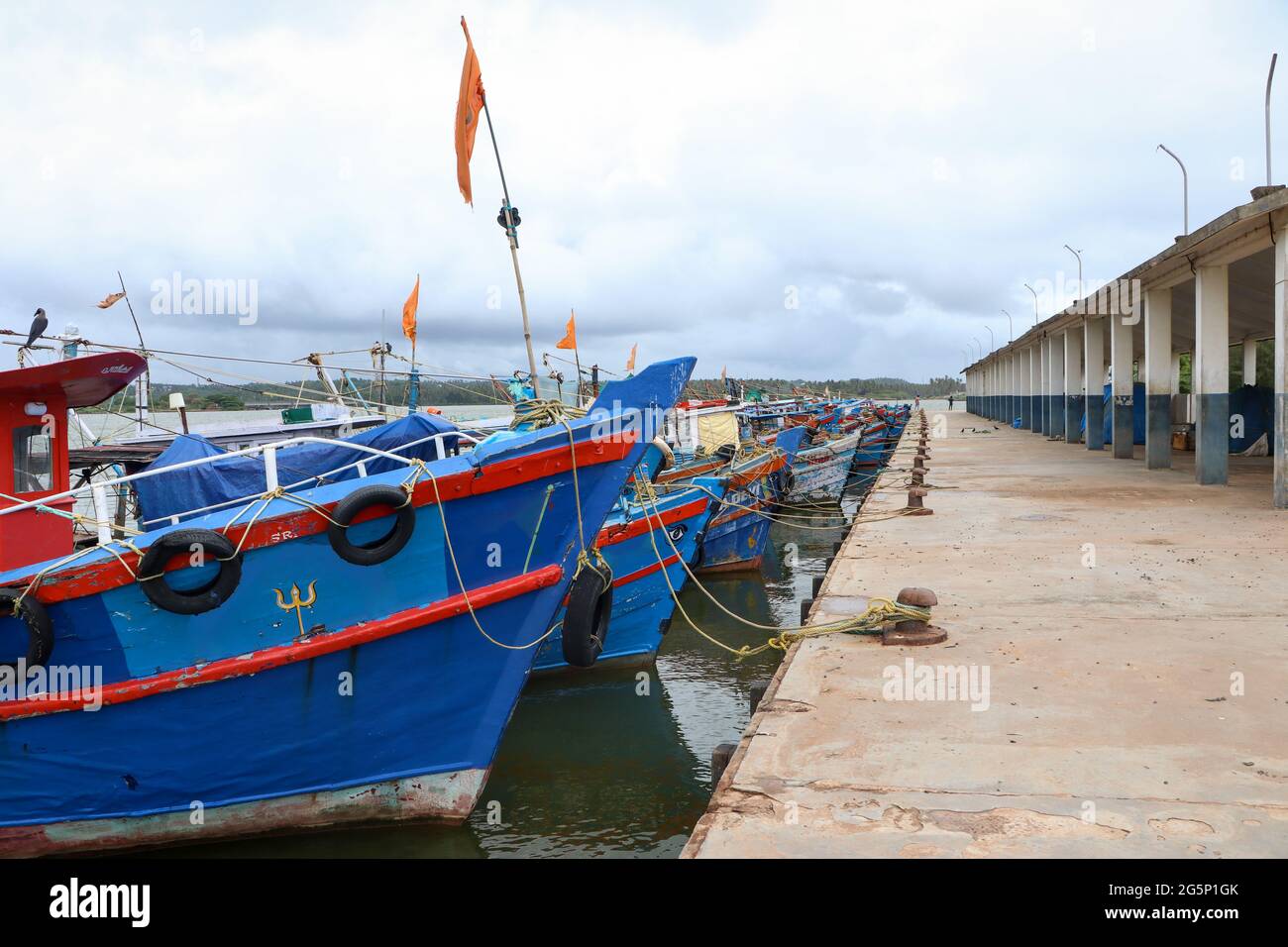 orange and blue fishing motor boats lined up in a fishing sea harbor in ...