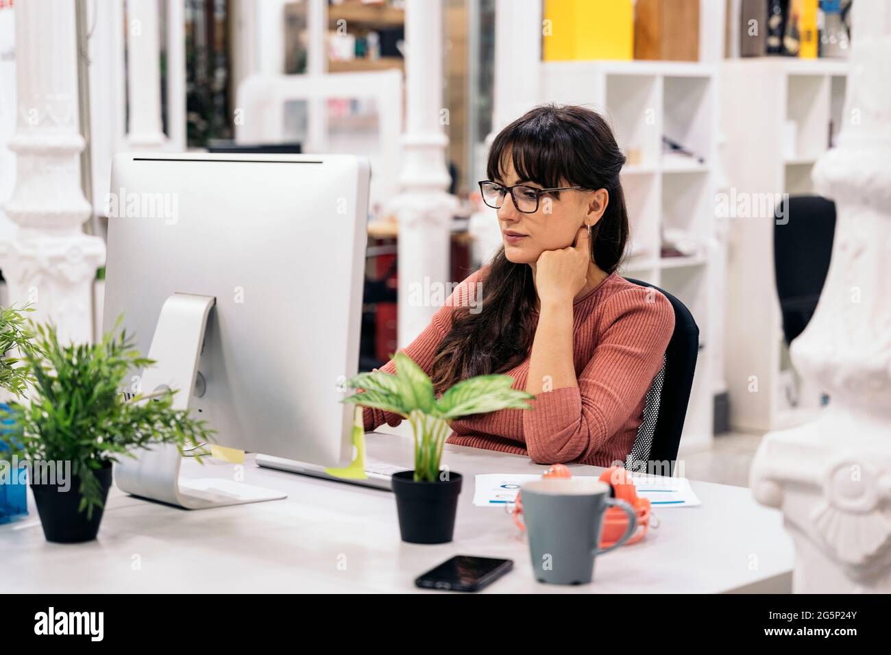 Focused office worker using computer and working in the office. Co ...