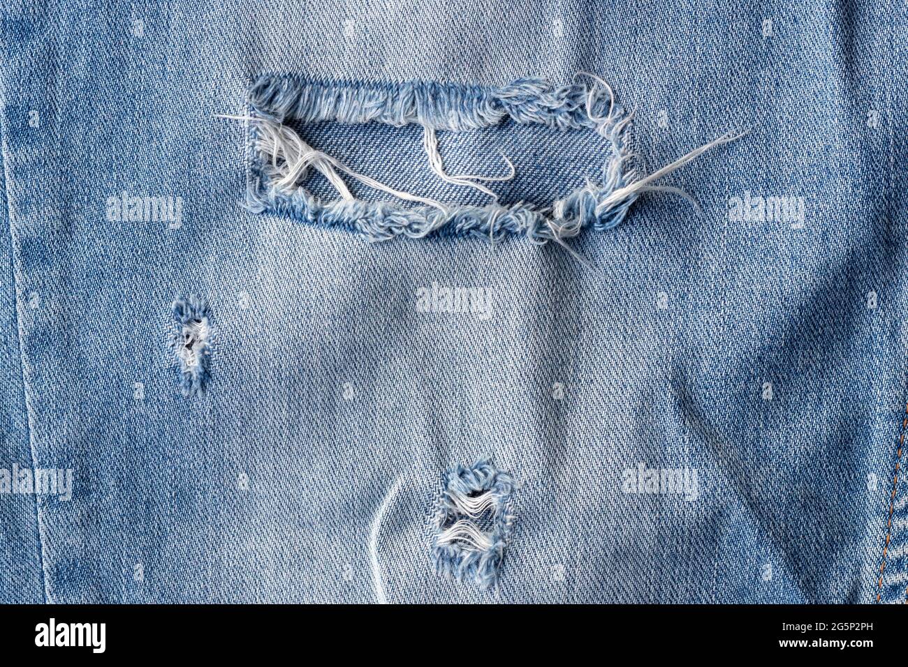 Blue torn jeans fabric texture. Distressed denim with hole and seam ...
