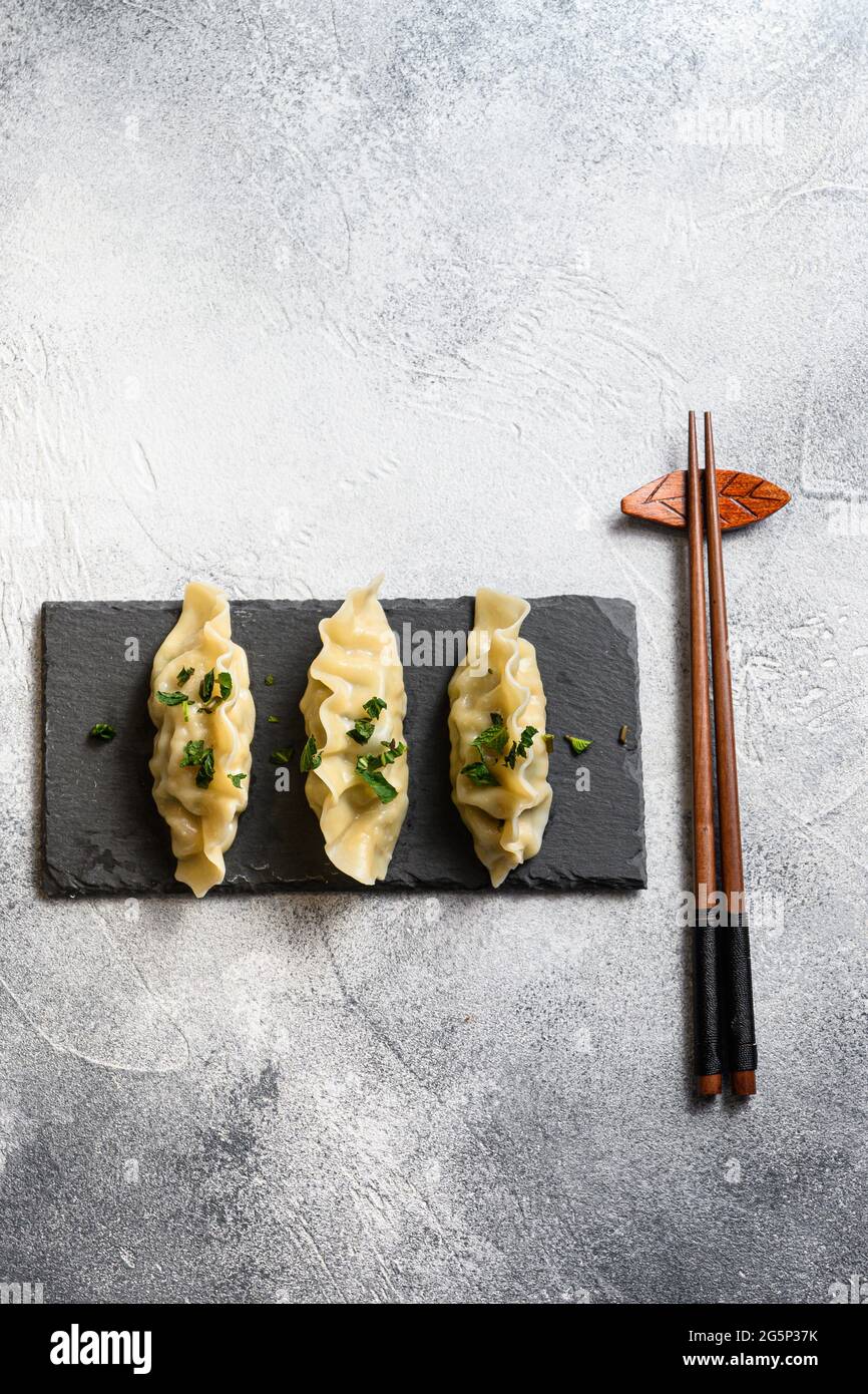 Boiled Japanese gyoza, dumplings snack on black stone board slate over ...