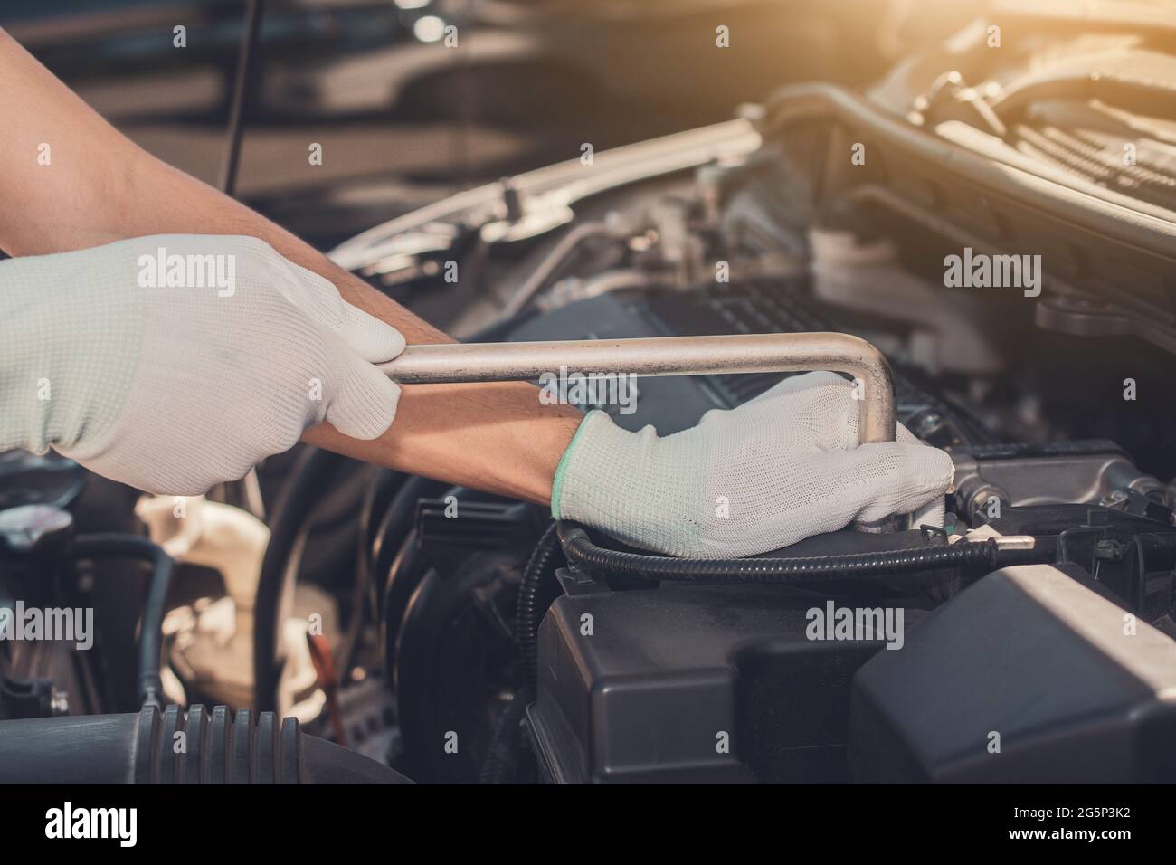 Repairman mechanic fixing a car with a socket wrench Stock Photo - Alamy