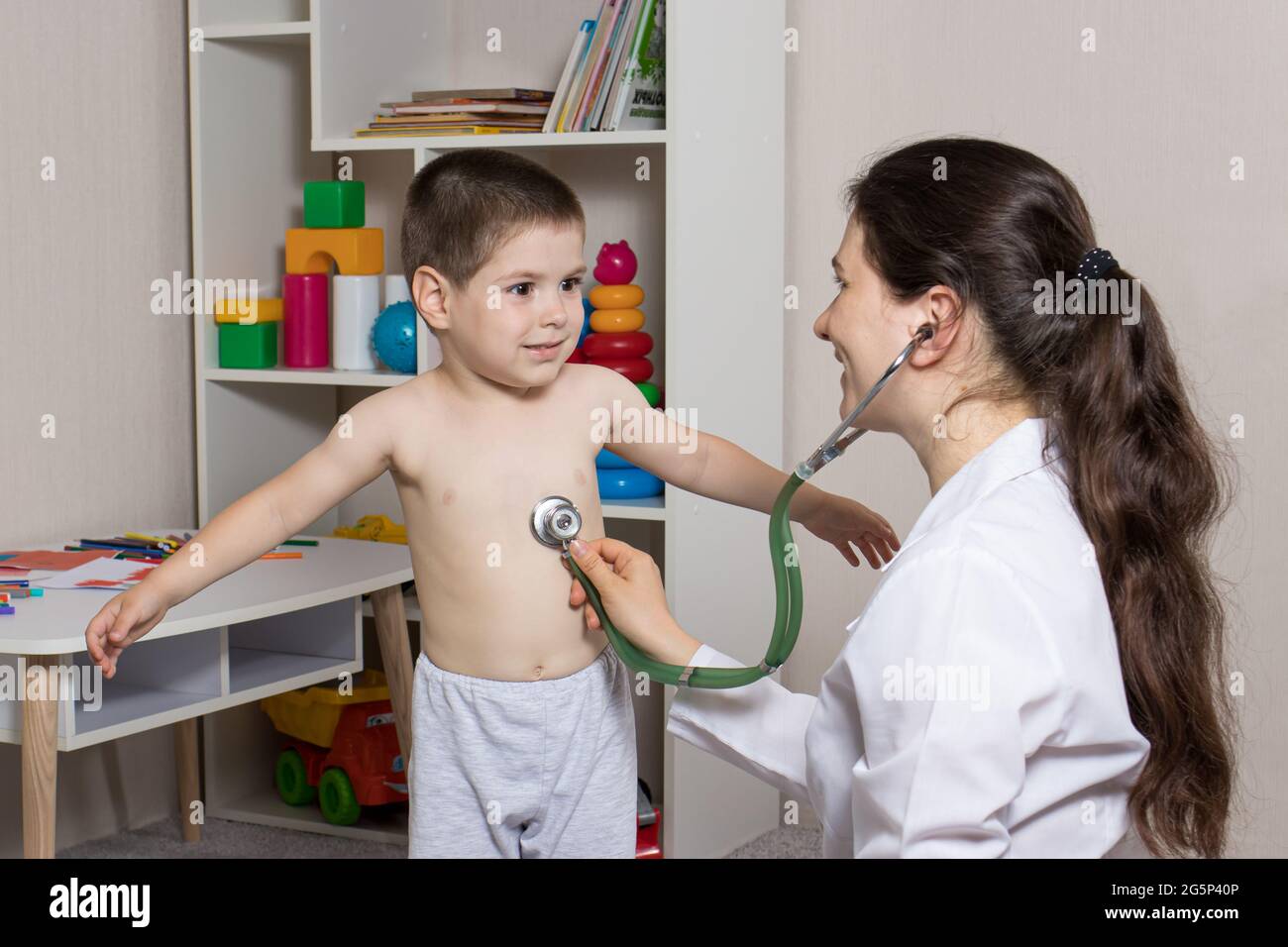 Pediatric examination of a child with a stethoscope. Little boy and ...