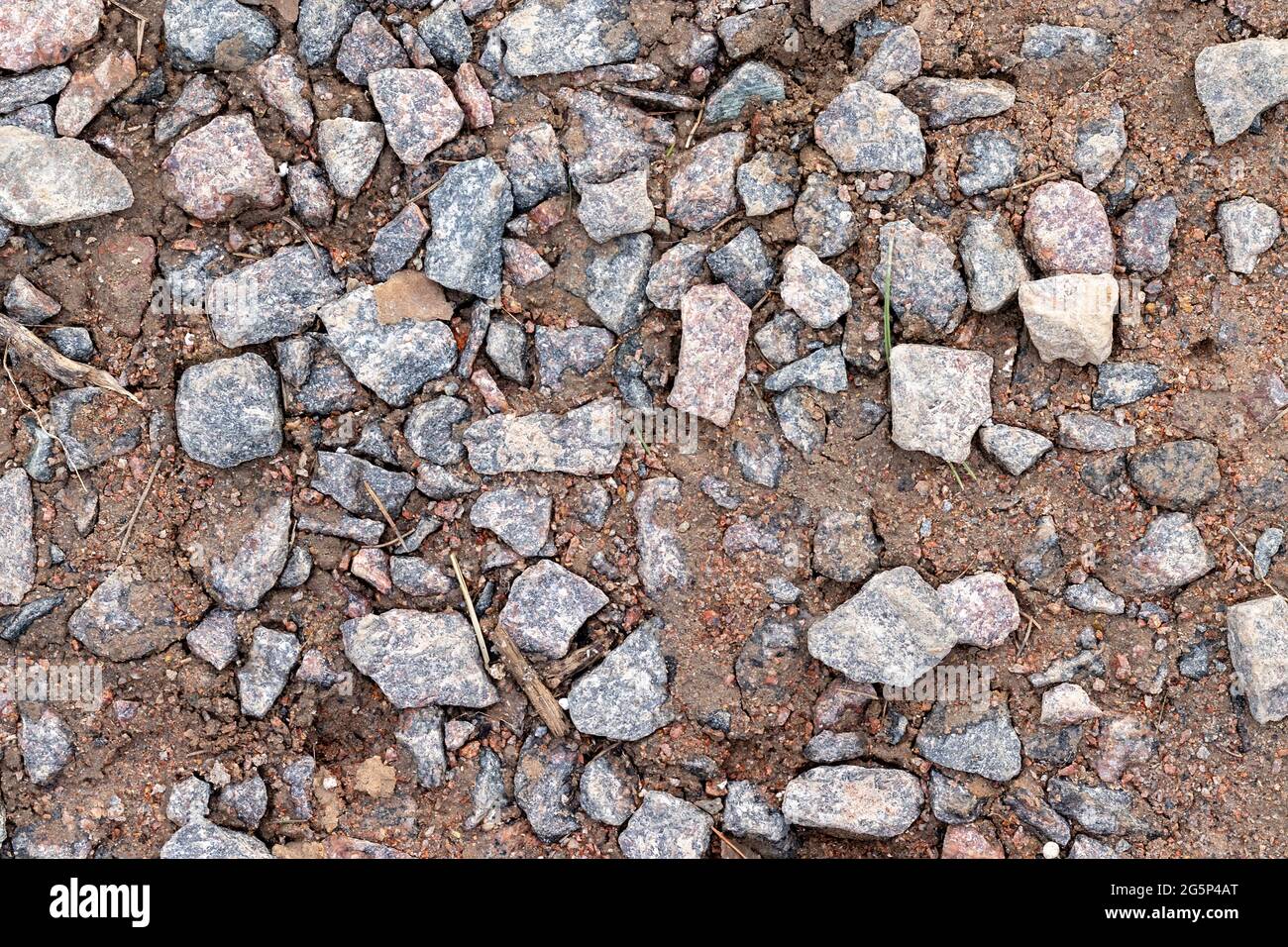 Wet moist ground with lots of granite stones. Natural gravel texture ...