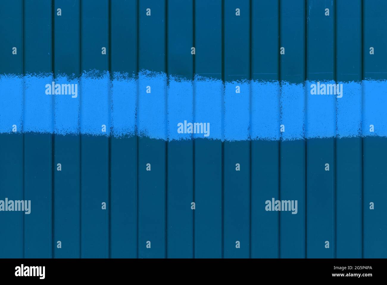 Dark classic blue metal fence with vertical corrugated stripes and with ...