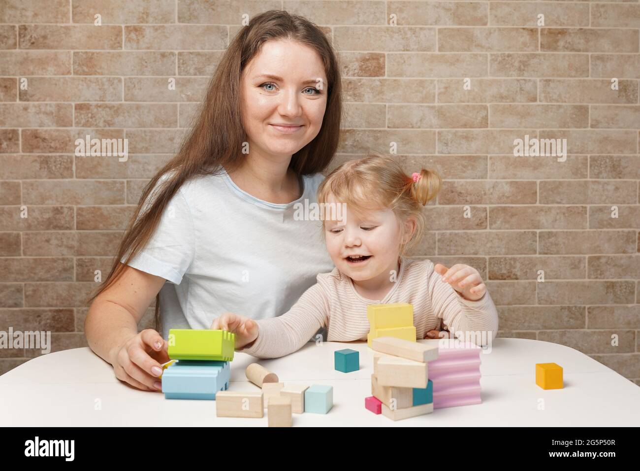Mother with a child playing with wooden blocks at home Stock Photo - Alamy