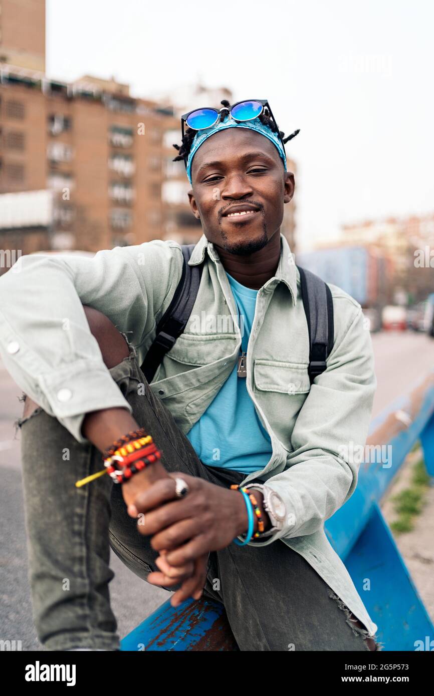Attractive african boy with dreadlocks smiling and looking at camera ...