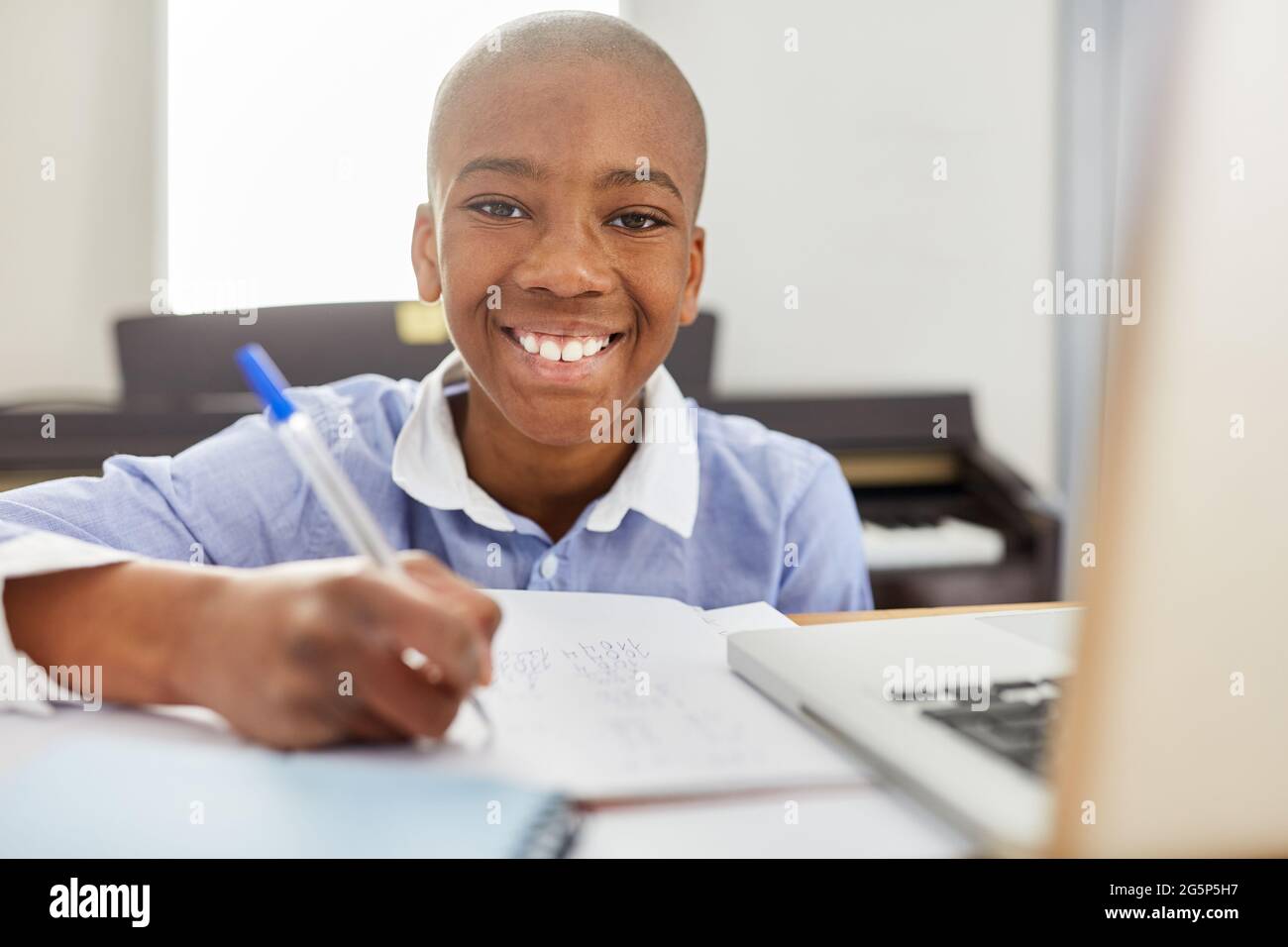 Smiling boy as a student doing homework homeschooling in distance class ...