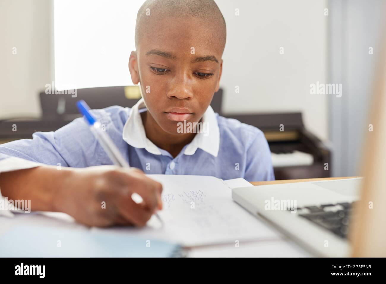 African boy as a hardworking student doing homework in distance ...