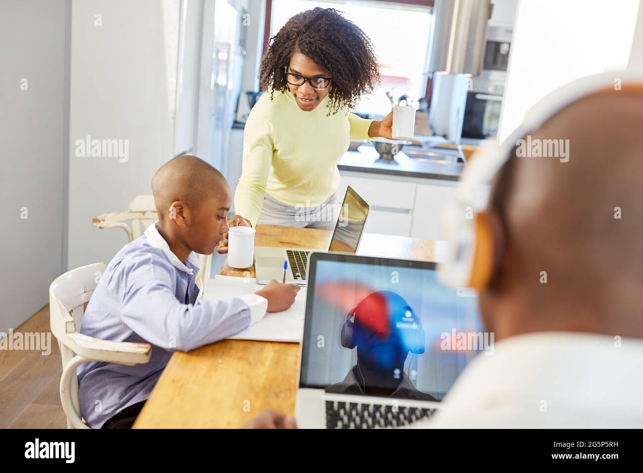 Parents and son at the computer online while homeschooling in the ...