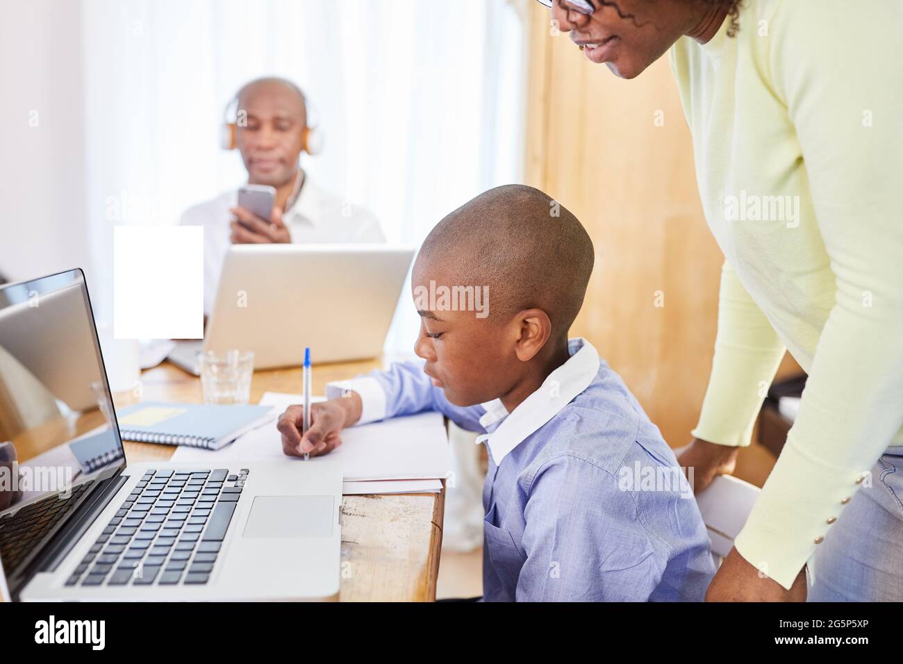 Students doing homeschooling at the computer in the living room as home ...
