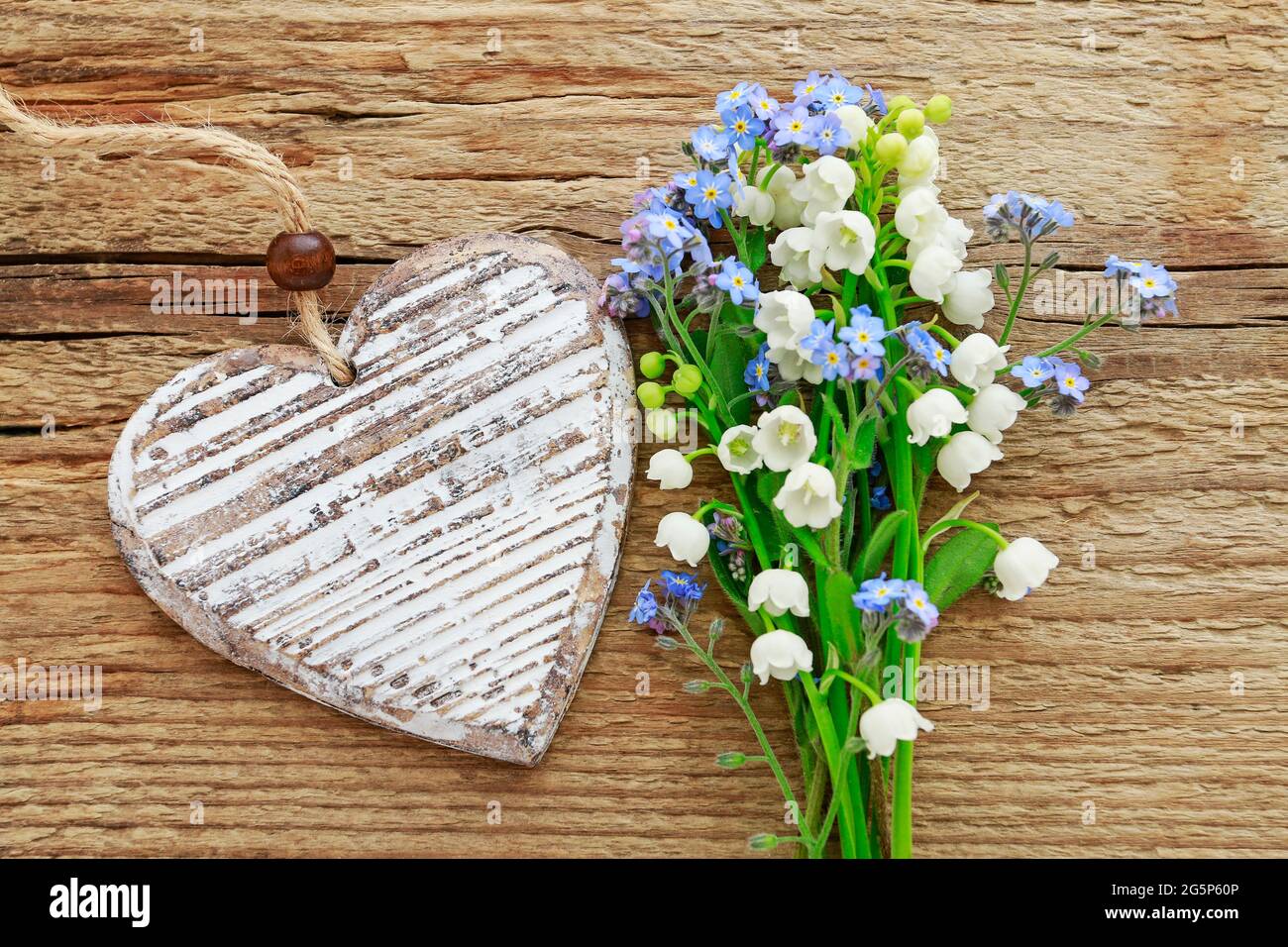 Bouquet of forget-me-not and lily of the valley flowers on wooden ...